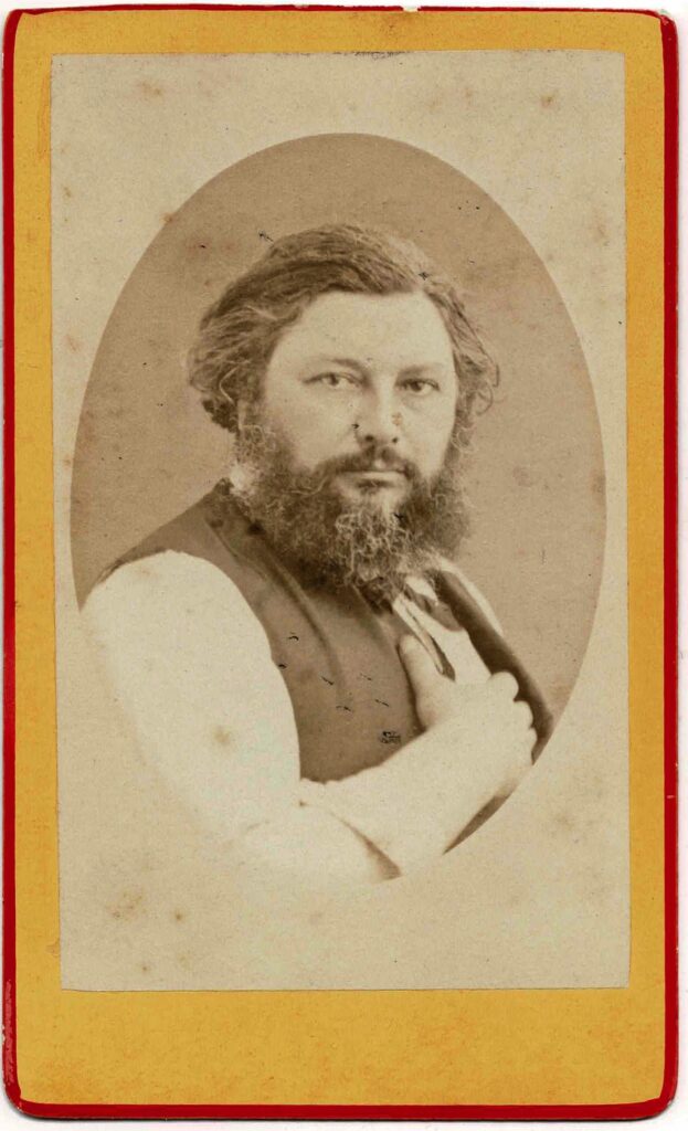 Gustave COURBET photographié de trois quarts, la main sur le coeur.